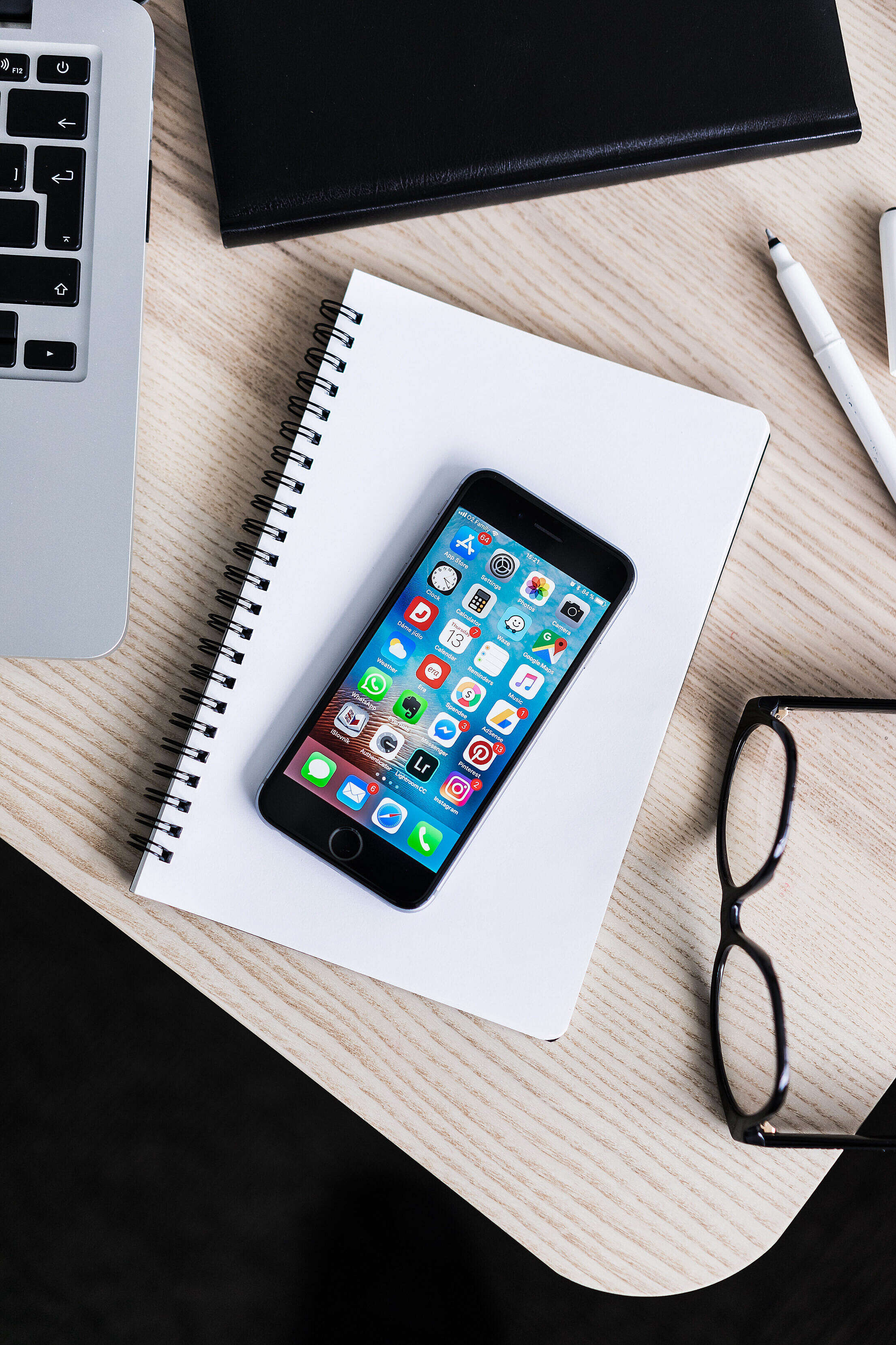 iPhone Lying on Notebook and Wooden Desk Mockup Free Stock Photo | picjumbo